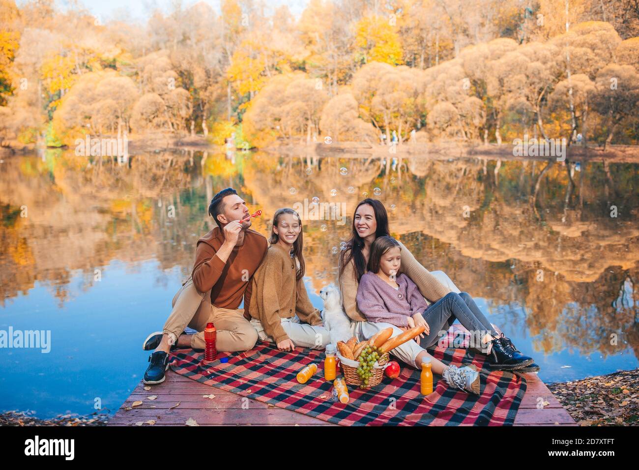 Beautiful family at autumn warm day near lake Stock Photo - Alamy