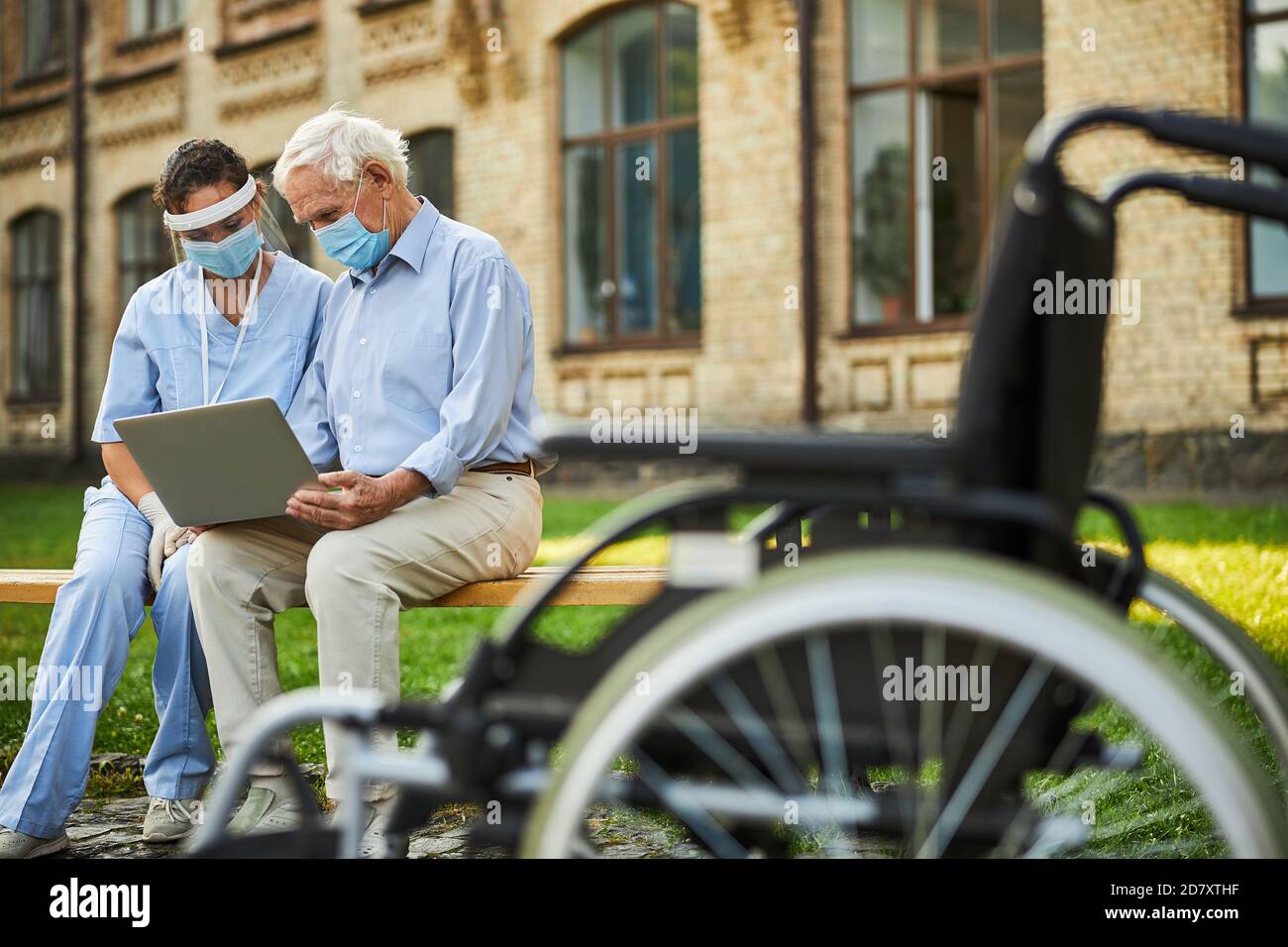 Two people looking at the screen of computer outdoors Stock Photo - Alamy