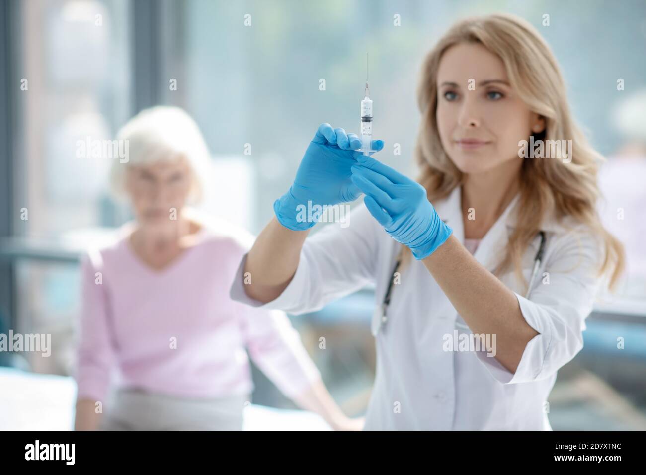 Cute female nurse holding an ampule with vaccine Stock Photo - Alamy