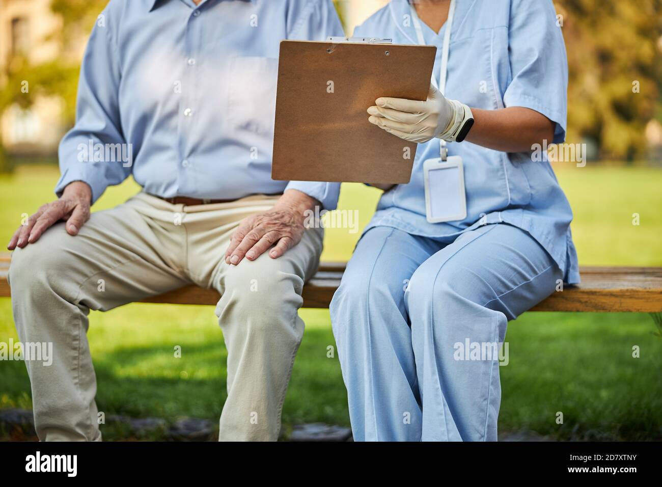 Nurse holding file folder and sitting near her patient Stock Photo - Alamy