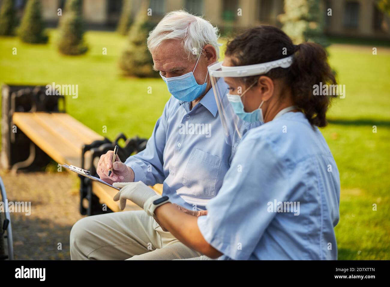 Nurse and old patient on bench near elderly home Stock Photo - Alamy