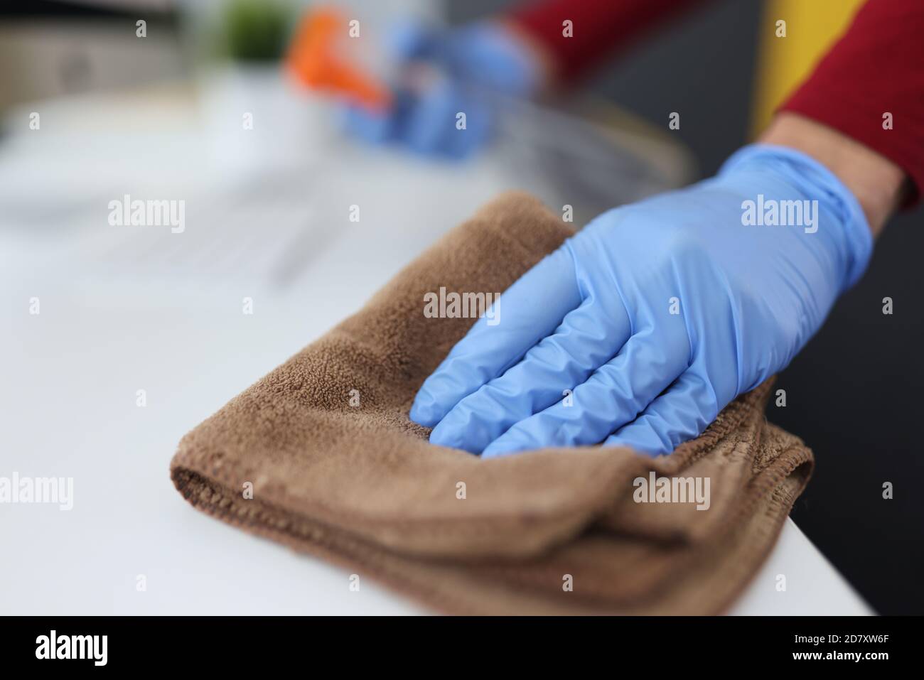 Gloved hand holds microfiber cloth and wipes table Stock Photo - Alamy