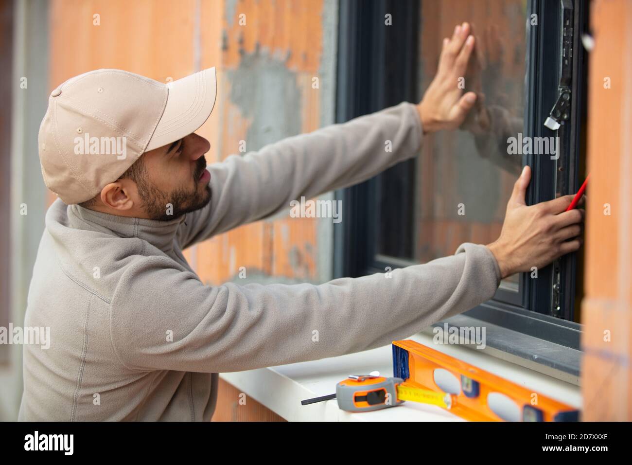 handsome young man installing bay window Stock Photo - Alamy