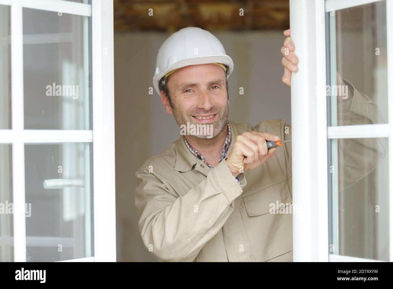 portrait of middle-aged glazier working on window Stock Photo - Alamy
