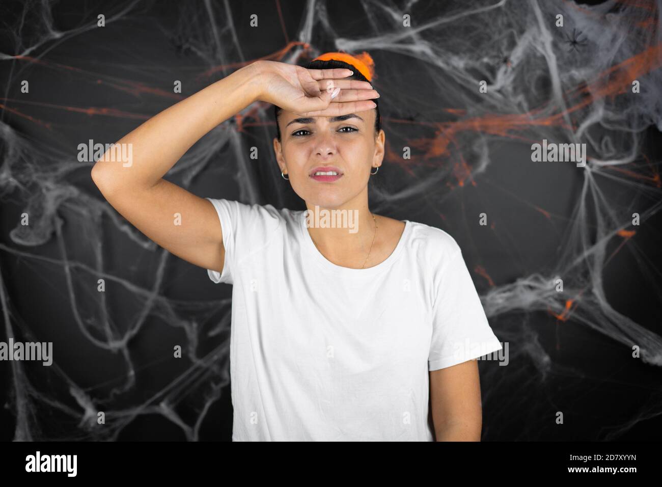 Young beautiful woman over black background with cobwebs and spiders ...