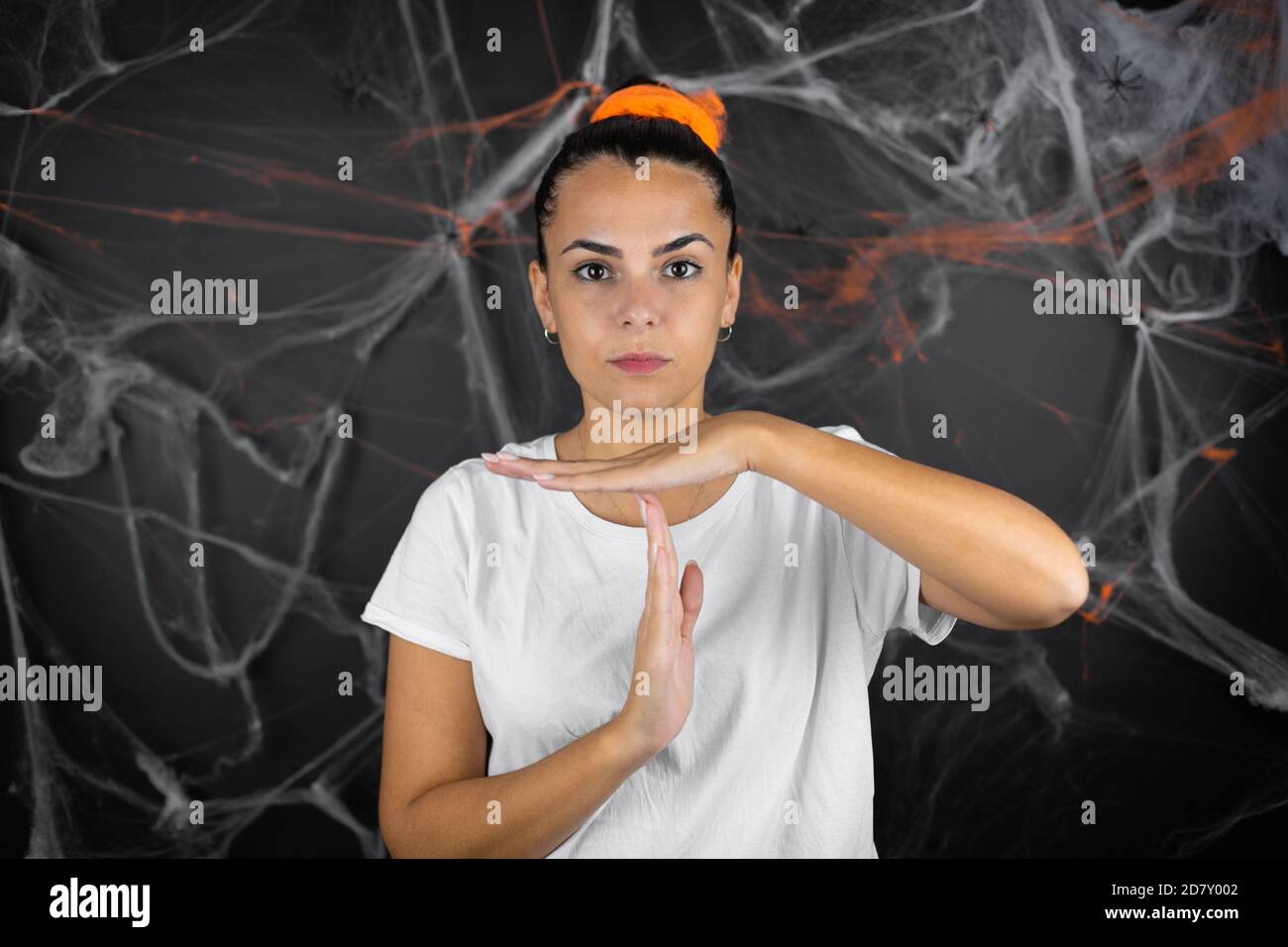 Young beautiful woman over black background with cobwebs and spiders ...