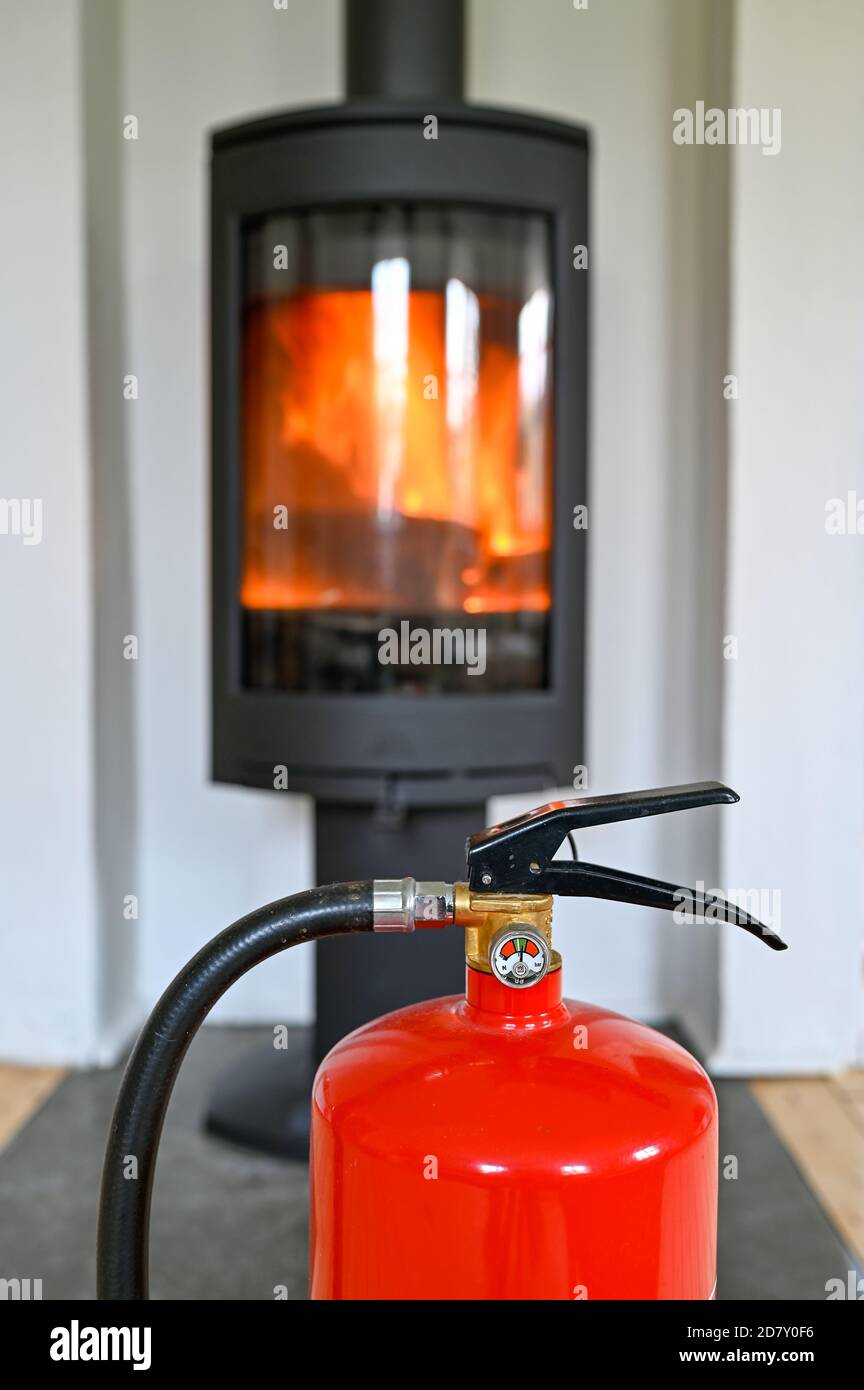 red fire extinguisher standing infront of a fireplace in livingroom ...