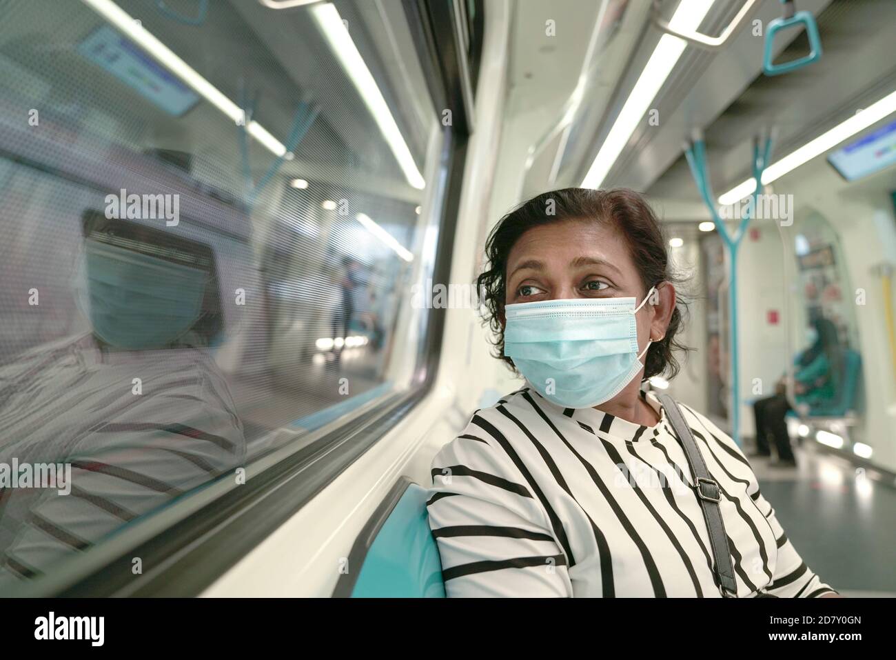 Woman commuter wearing face mask inside subway train. Travel new normal ...
