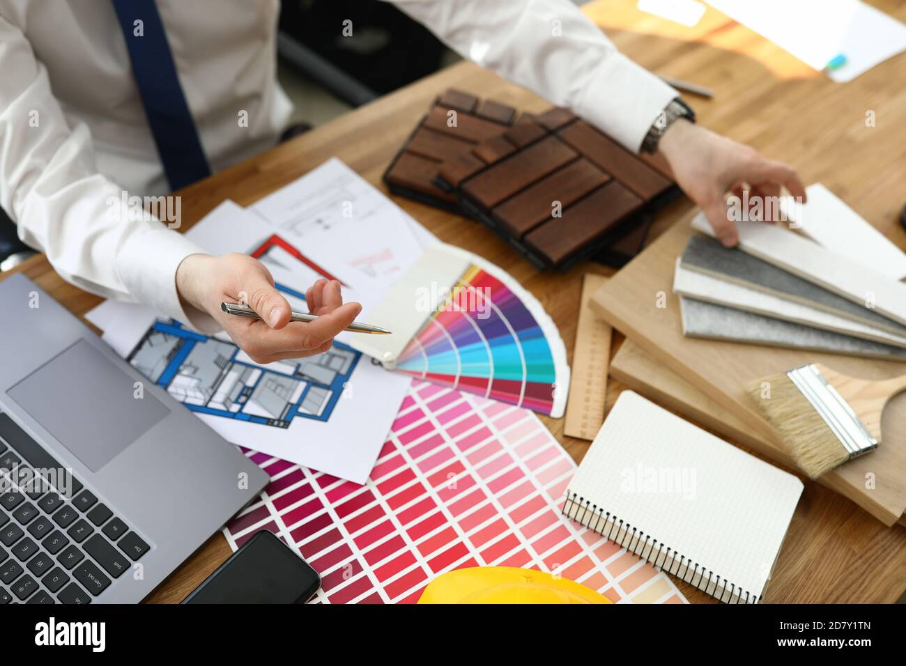 Male hands above table on which samples of finishing materials and ...