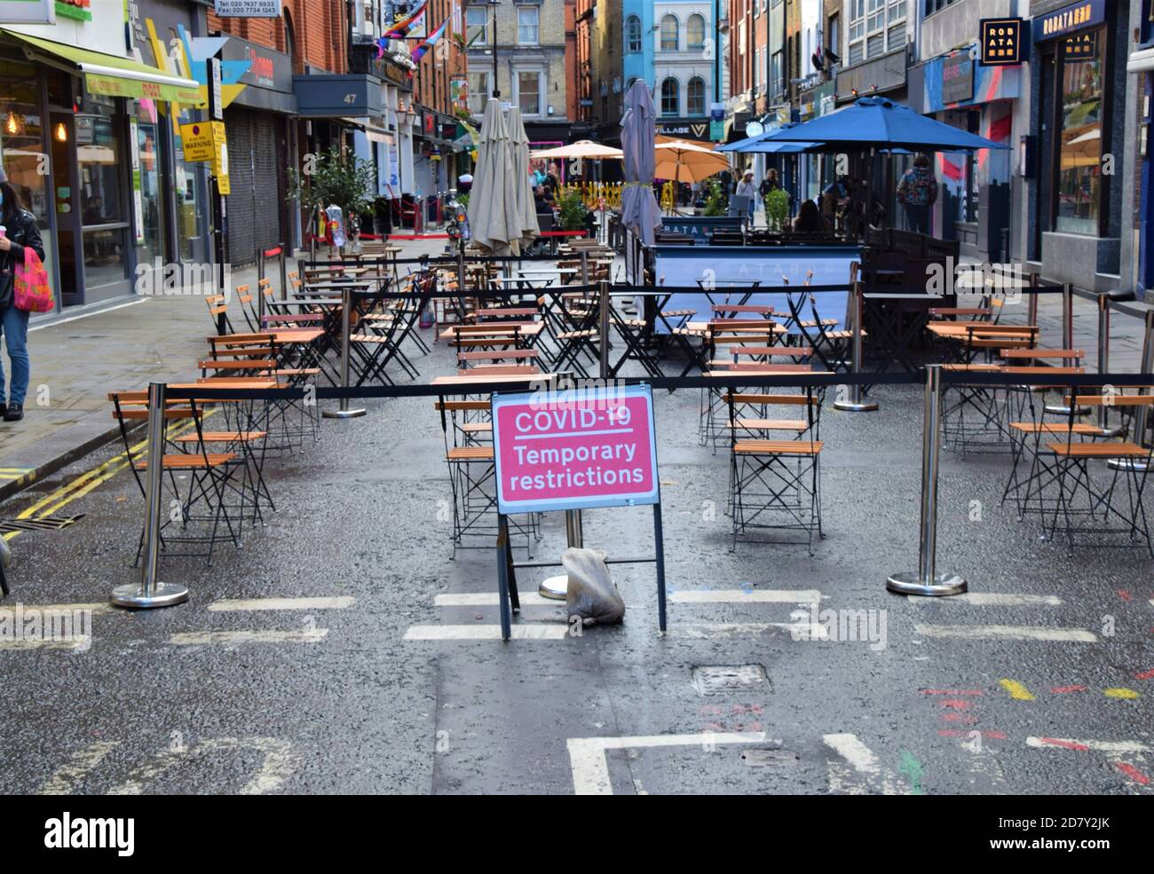 Covid-19 Temporary Restrictions street sign and empty tables in Old ...