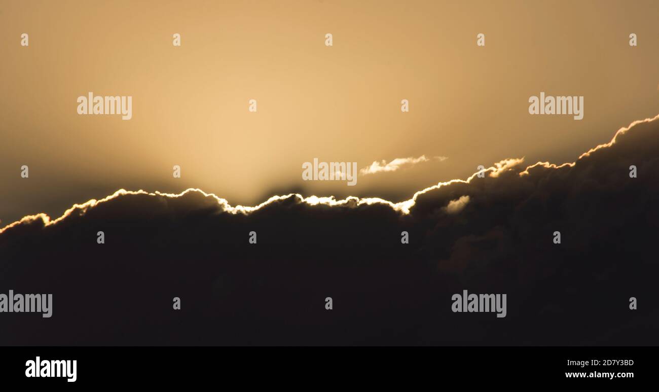 Sunset. Sun behind grey clouds making silver lining effect. Springtime ...