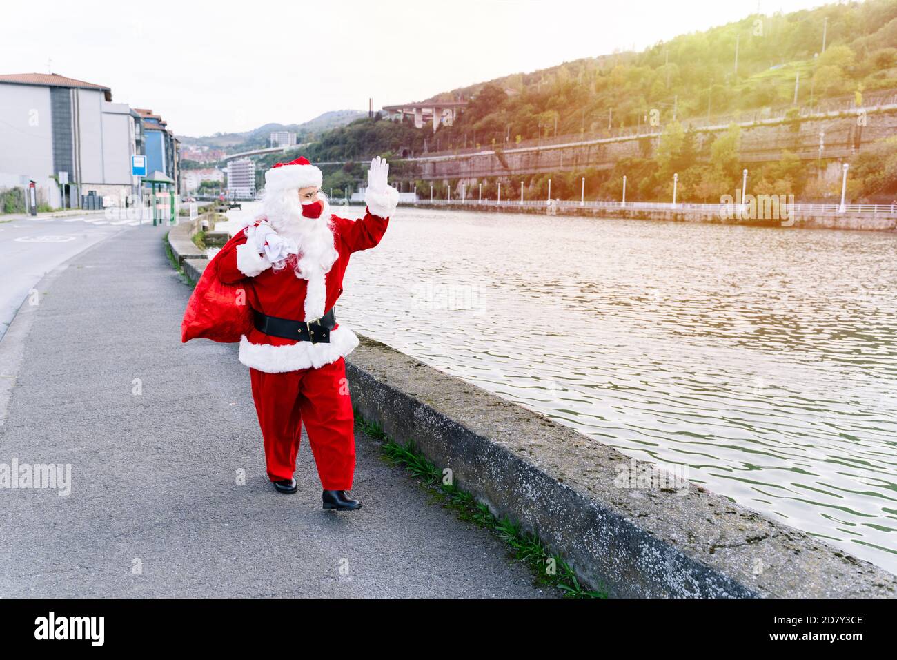 Portrait of Santa Claus walking down the street with a sack of presents ...