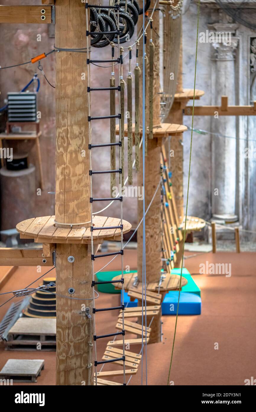 Indoor adventure park with masts, platforms and climbing ropes Stock ...