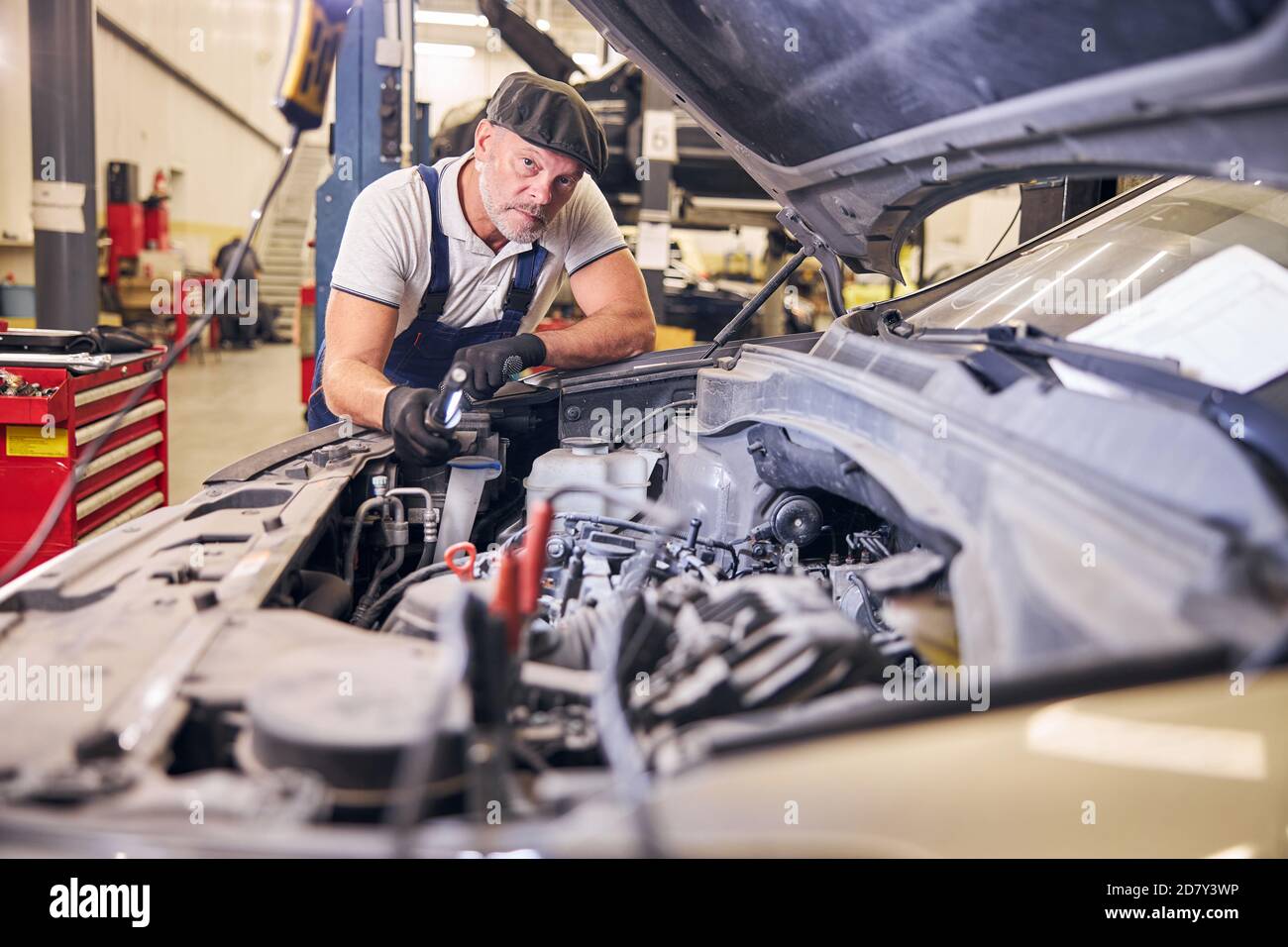 Handsome auto mechanic working at car repair service station Stock ...
