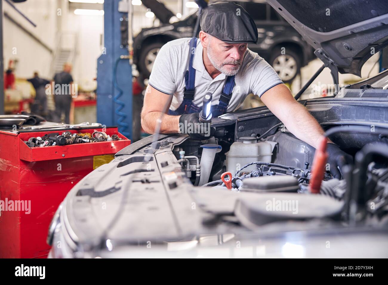Bearded auto mechanic fixing car engine at service station Stock Photo ...
