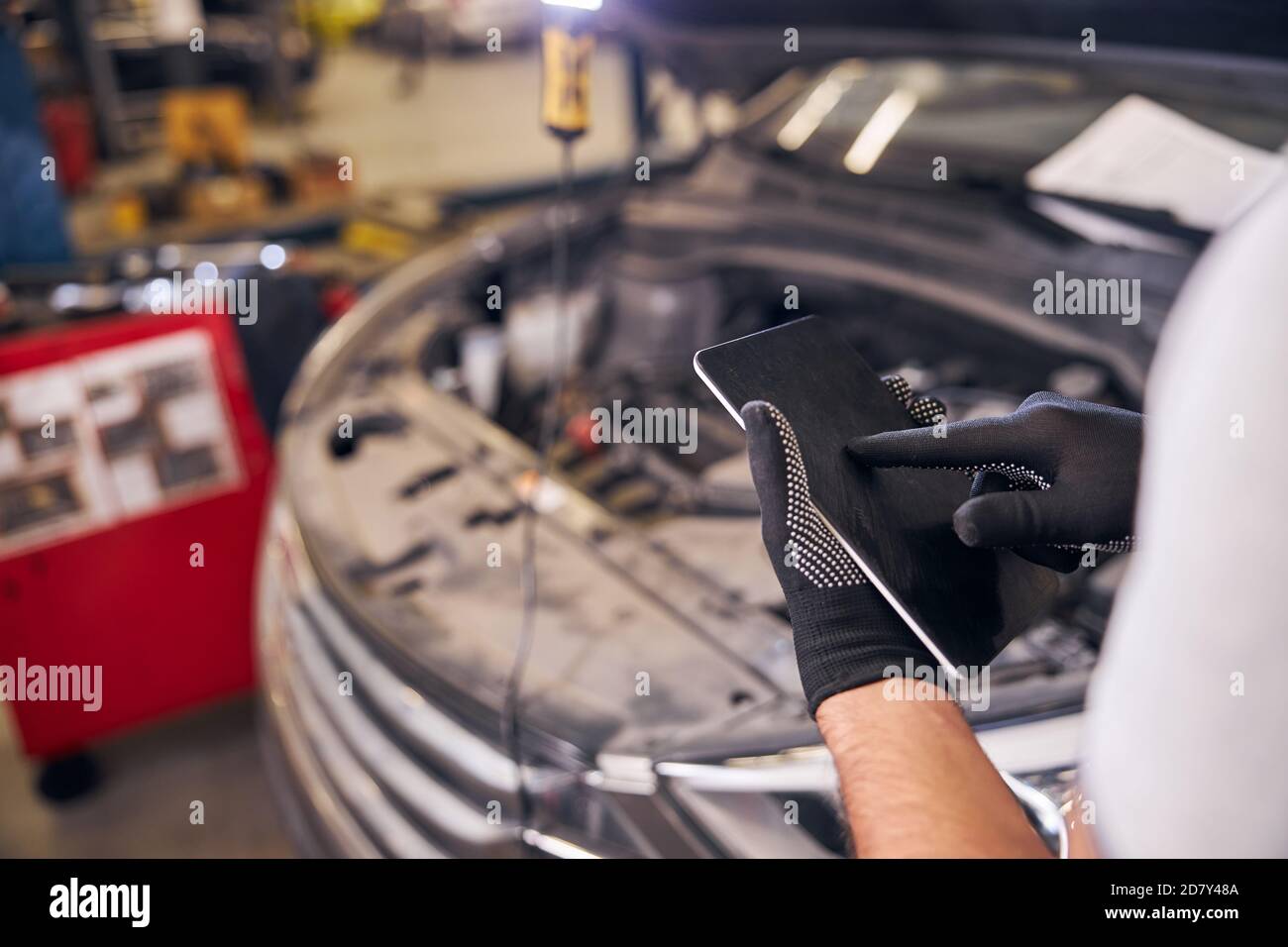 Male worker using tablet computer at auto repair station Stock Photo ...