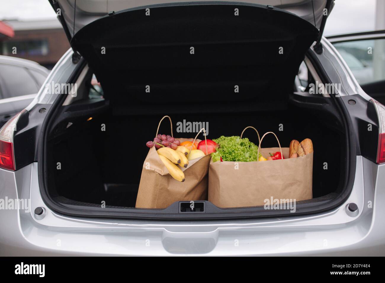 Groceries from a supermarket in a car trunk. Food delivery during ...