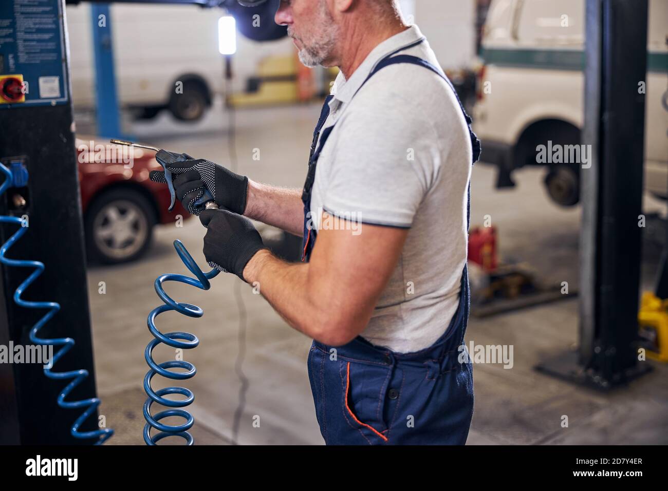 Auto mechanic using air blow gun at service station Stock Photo - Alamy