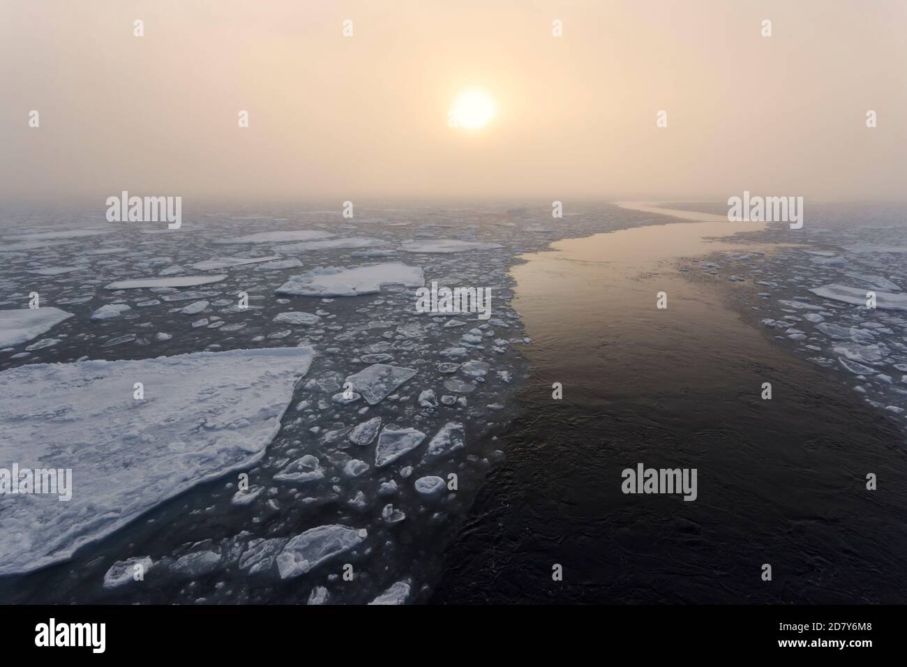 A path made by boat through pack-ice in the Arctic circle. The sun ...
