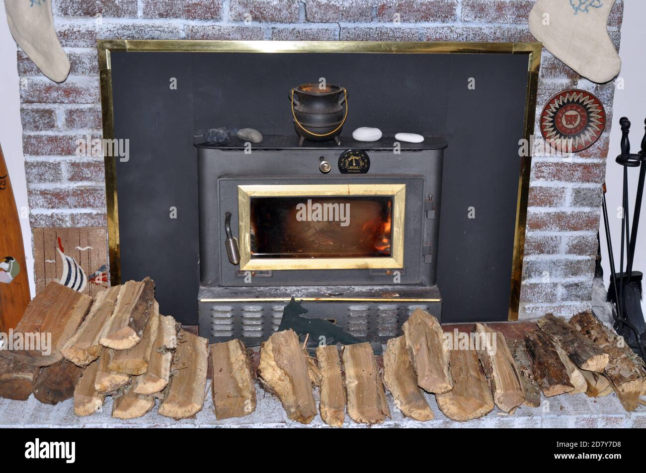 A Black and Gold Wood Burning Insert with wood in front Stock Photo - Alamy