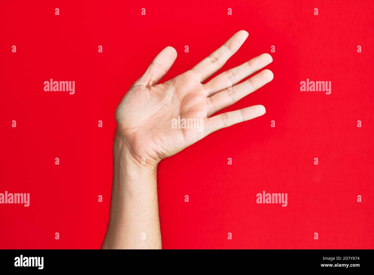 Arm of caucasian white young man over red isolated background ...
