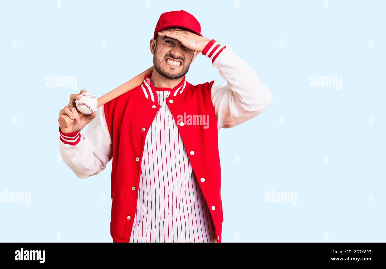 Young handsome man holding baseball bat and ball stressed and ...