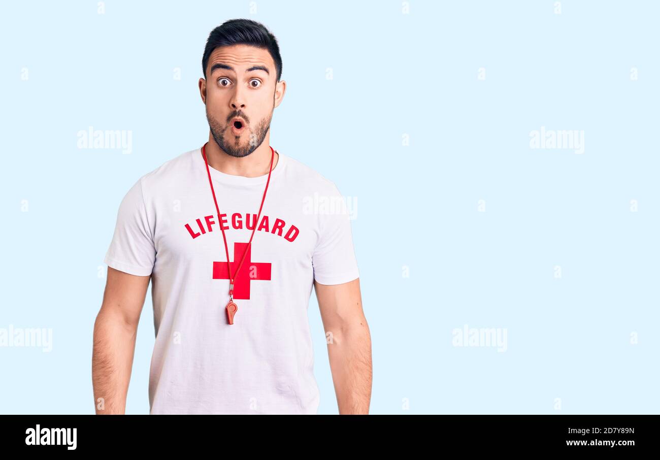Young handsome man wearing lifeguard uniform afraid and shocked with ...