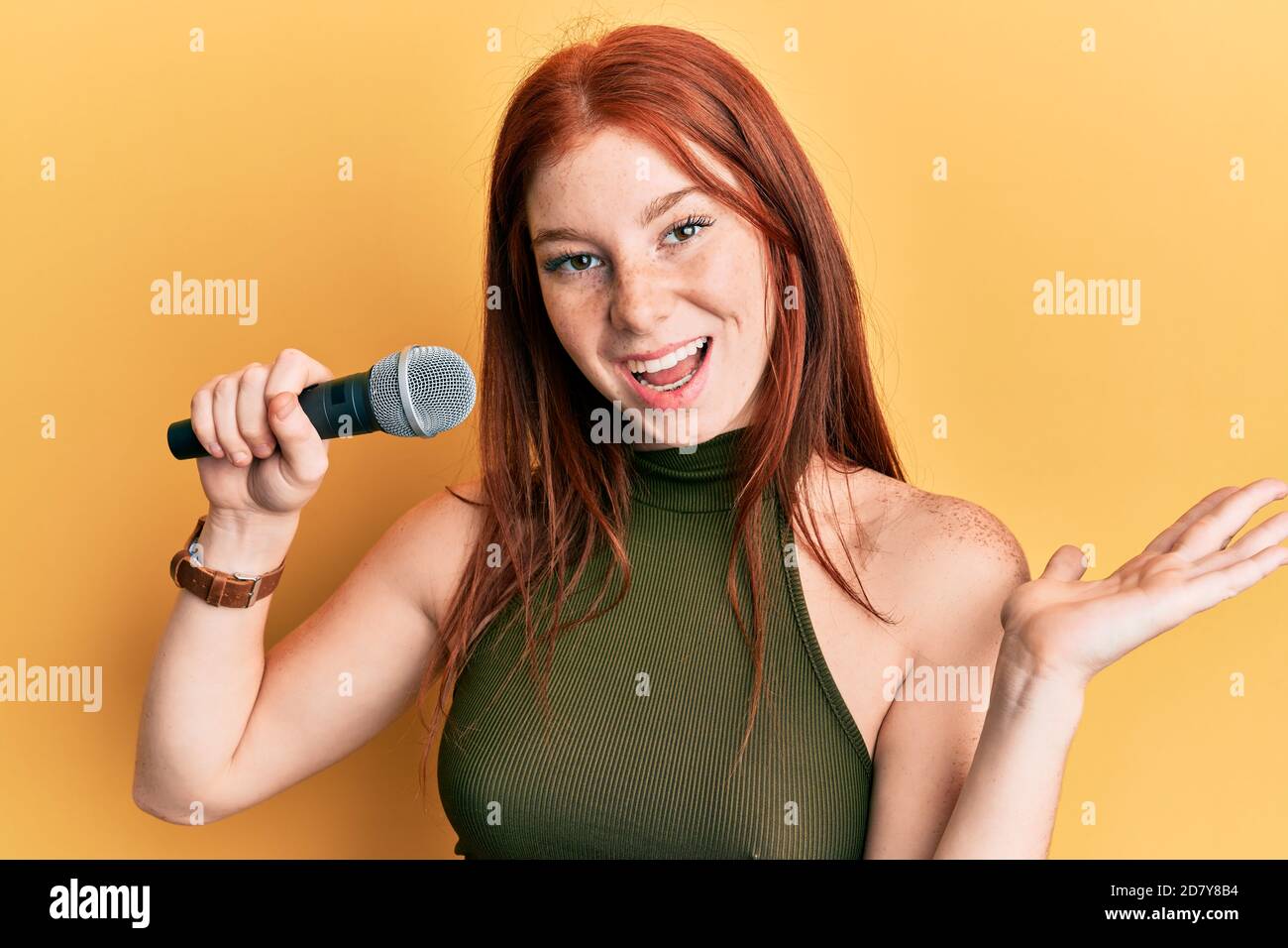 Young red head girl singing song using microphone celebrating ...