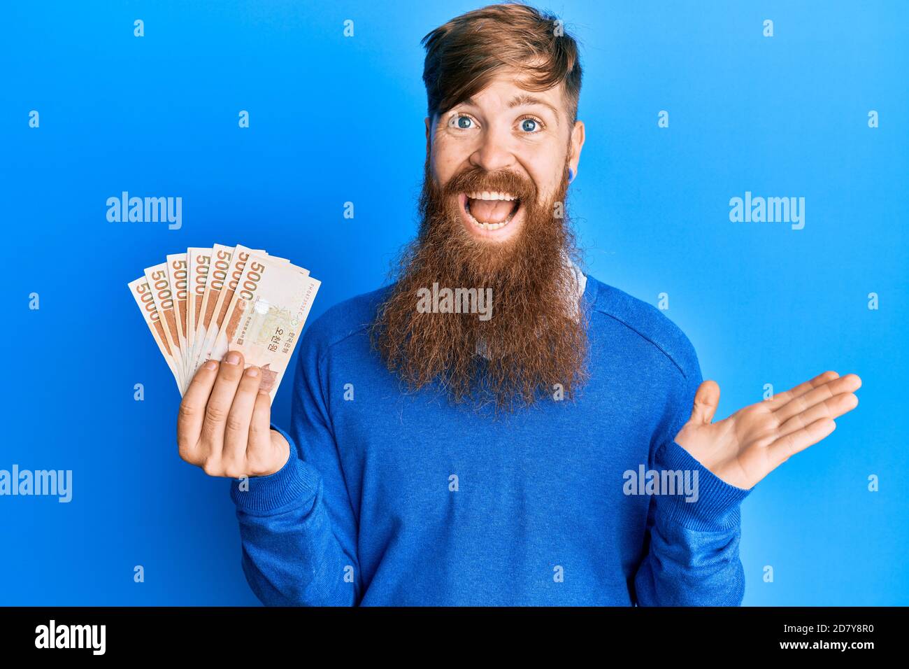 Young irish redhead man holding 5000 south korean won banknotes ...