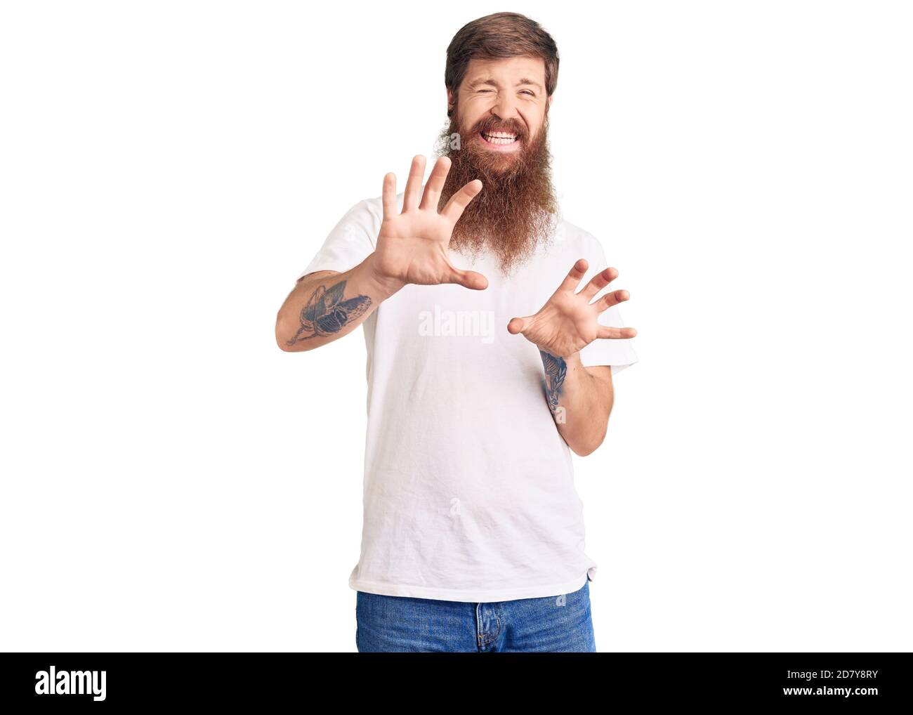 Handsome young red head man with long beard wearing casual white tshirt ...