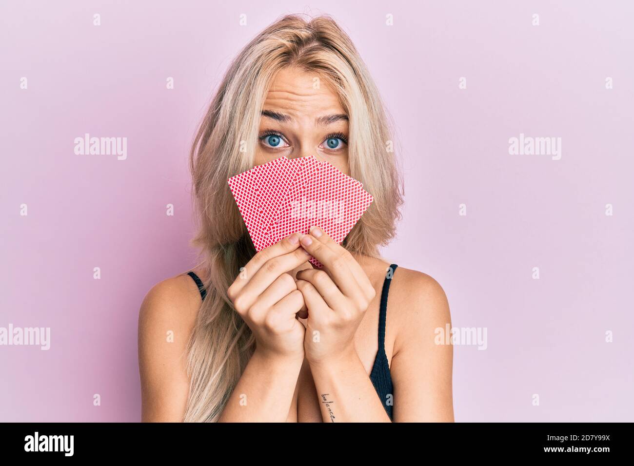 Beautiful caucasian blonde girl covering face with cards clueless and ...
