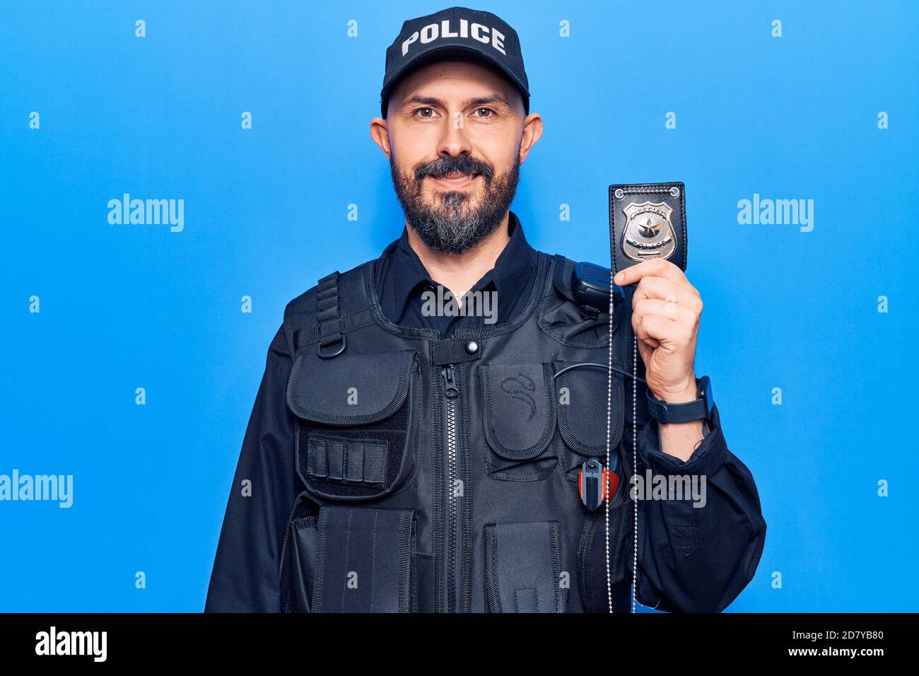 Young handsome man wearing police uniform holding gun looking positive ...