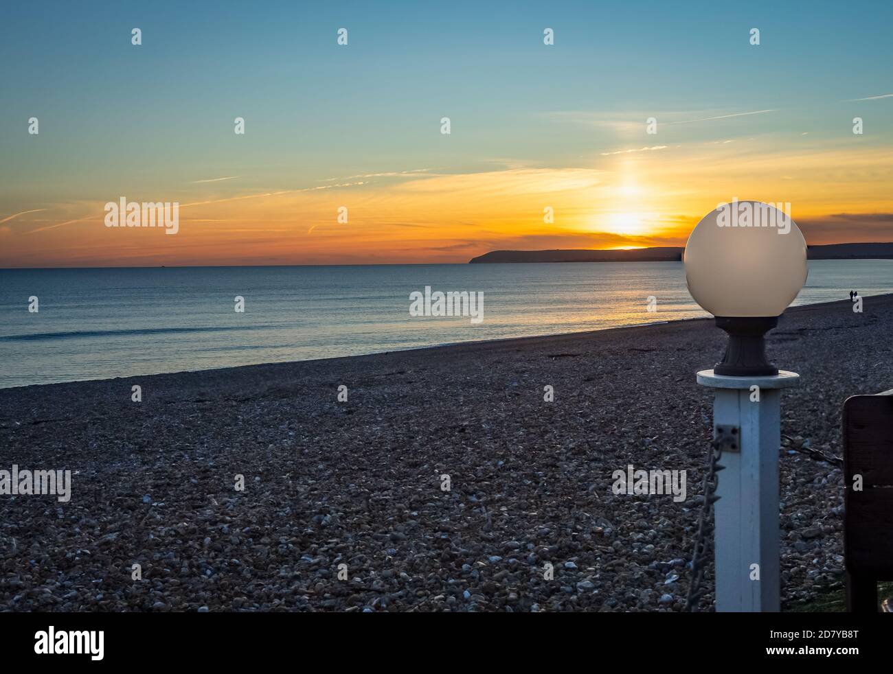 Sun setting over beach with seaside eating and lamp Stock Photo - Alamy