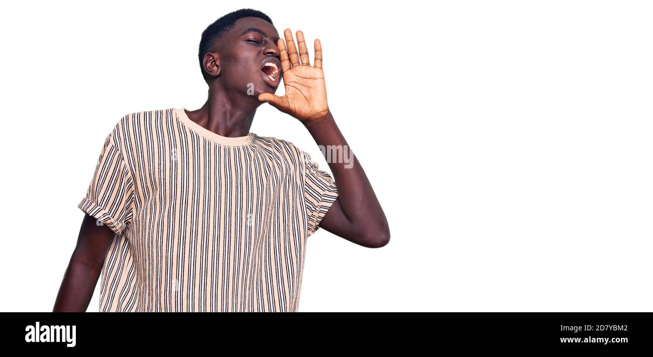 Young african american man wearing casual clothes shouting and ...