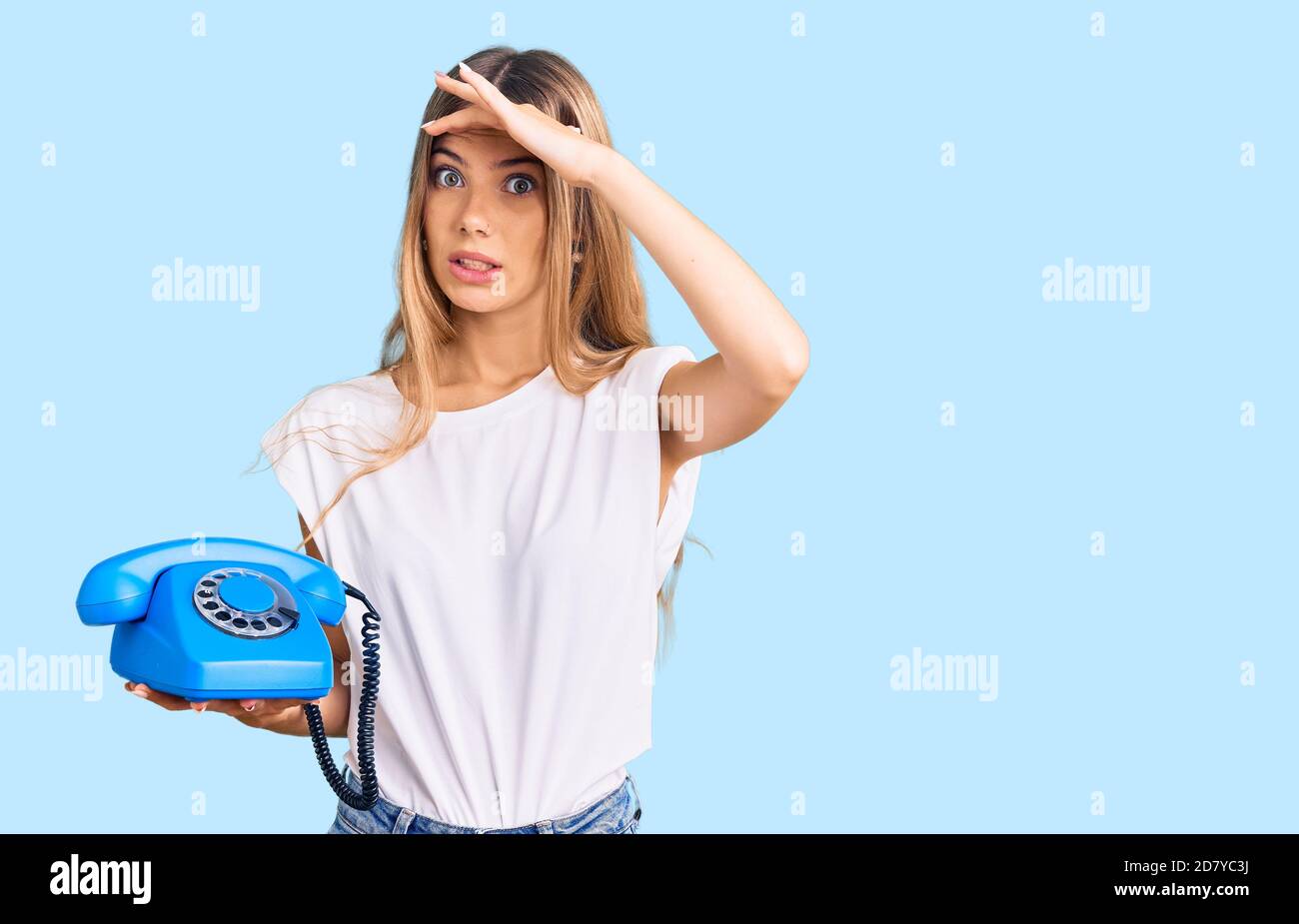 Beautiful caucasian woman with blonde hair holding vintage telephone ...