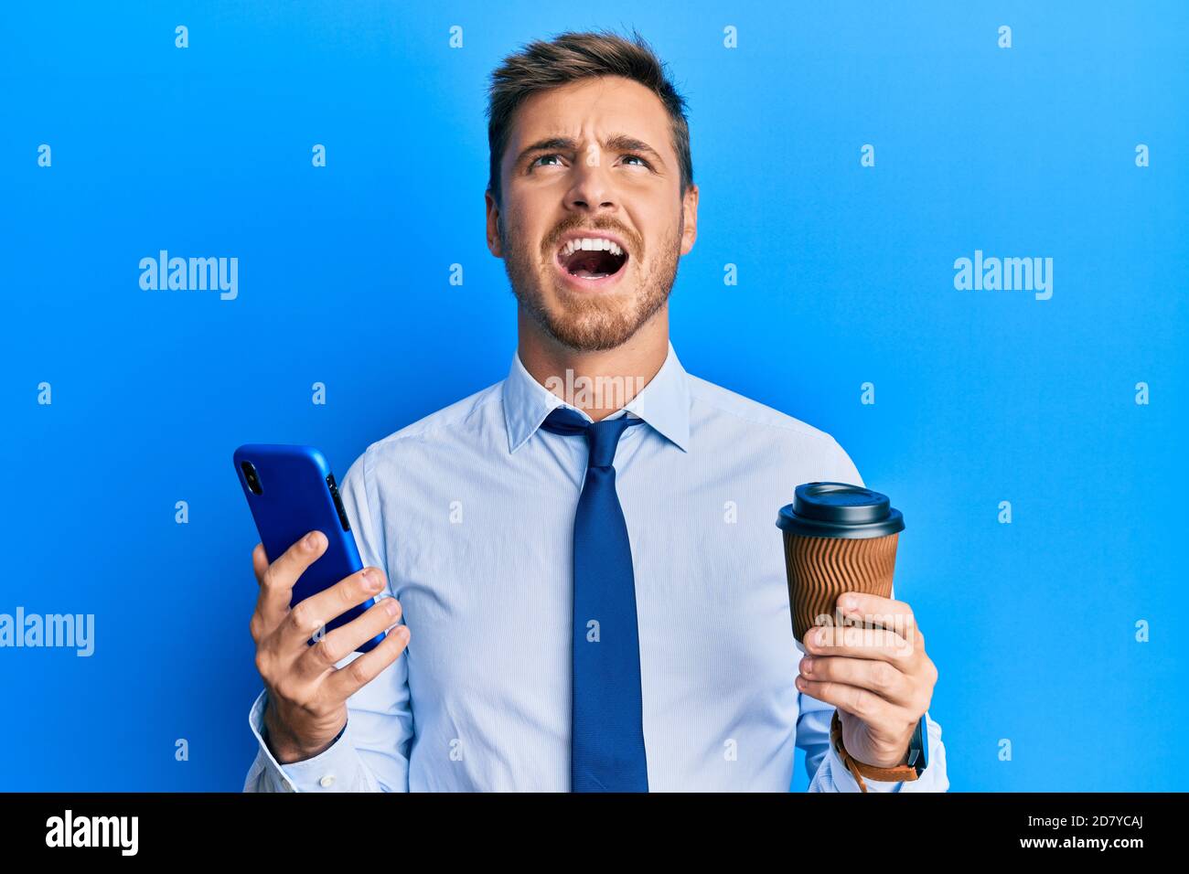 Handsome caucasian business man using smartphone and drinking a cup of ...