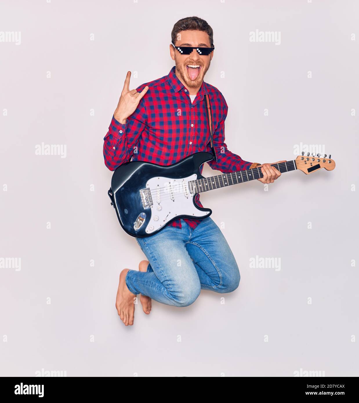 Young hispanic artist man wearing thug life sunglasses with open mouth ...