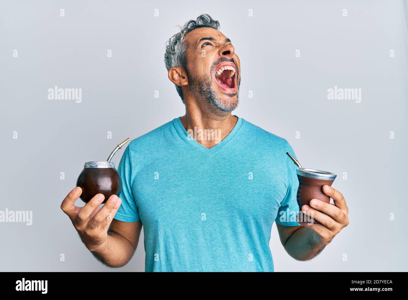 Middle age grey-haired man drinking mate infusion angry and mad ...