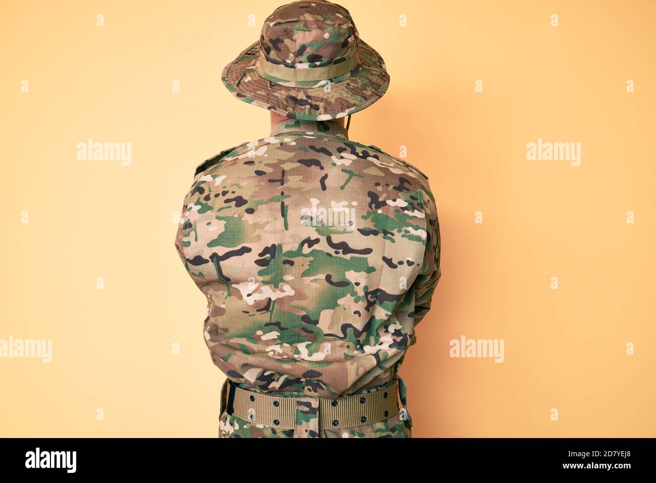 Young caucasian man wearing camouflage army uniform standing backwards ...