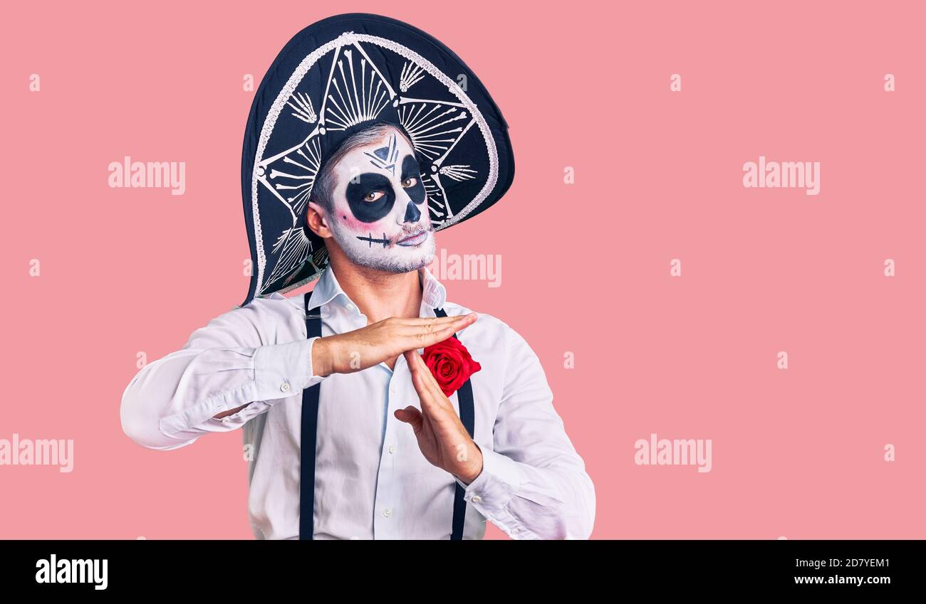 Man wearing day of the dead costume over background doing time out ...