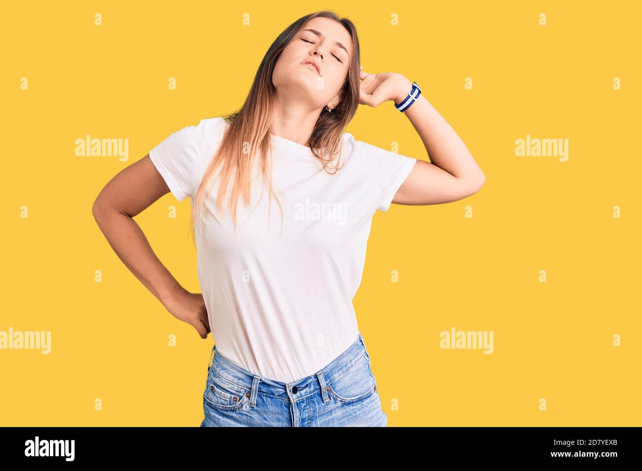 Beautiful caucasian woman wearing casual white tshirt stretching back ...