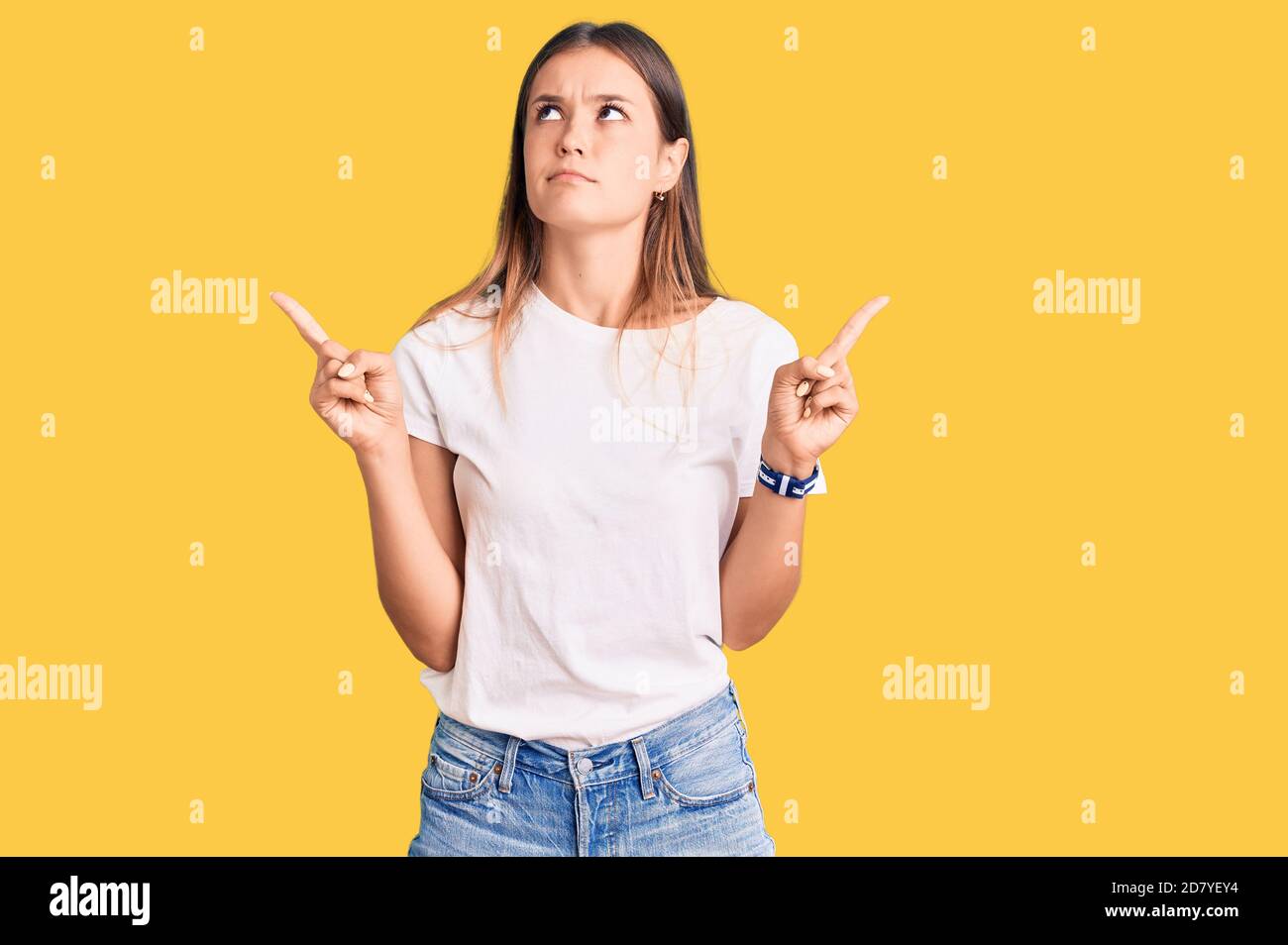 Beautiful caucasian woman wearing casual white tshirt pointing up ...
