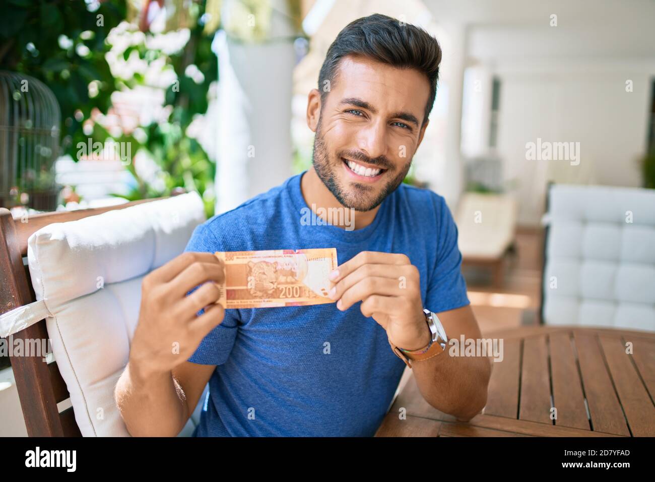 Young hispanic man smiling happy holding one south african rand ...