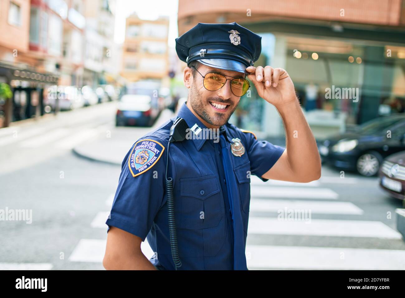 Young handsome hispanic policeman wearing police uniform smiling happy ...
