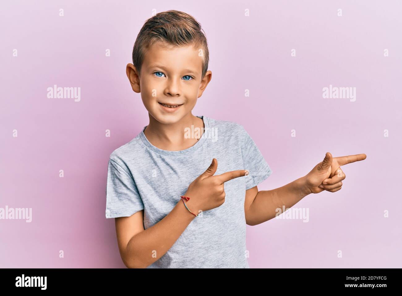 Adorable caucasian kid wearing casual clothes smiling and looking at ...