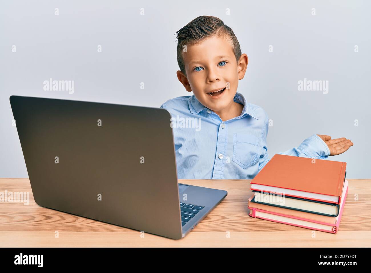 Adorable caucasian kid studying for school exam using laptop ...
