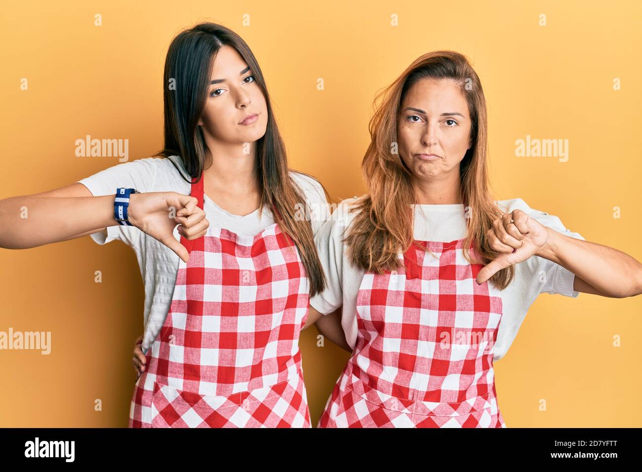 Hispanic family of mother and daughter wearing baker uniform over ...