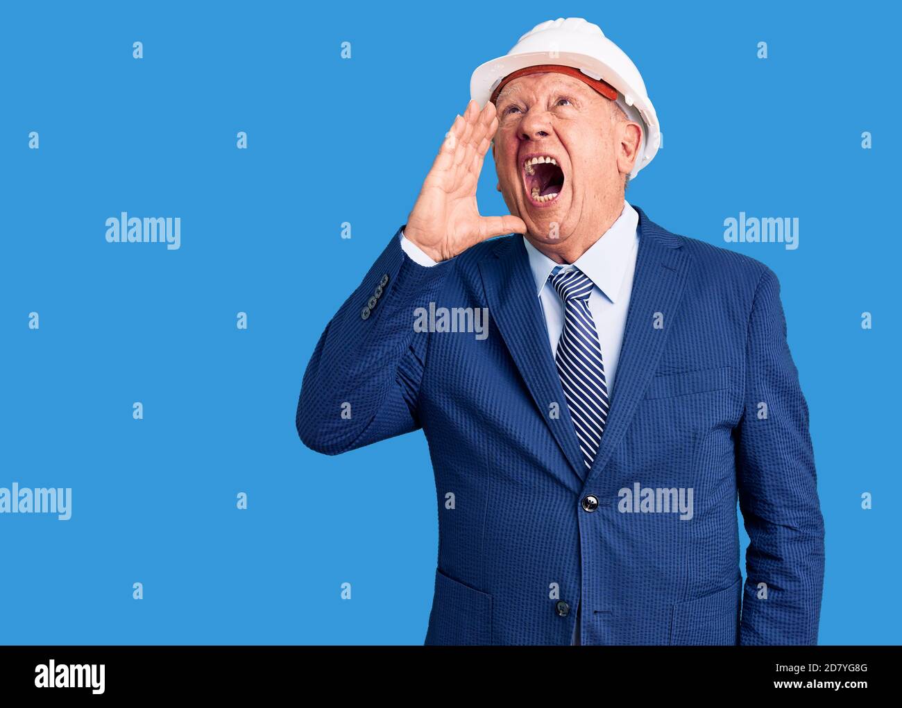 Senior handsome grey-haired man wearing suit and architect hardhat ...