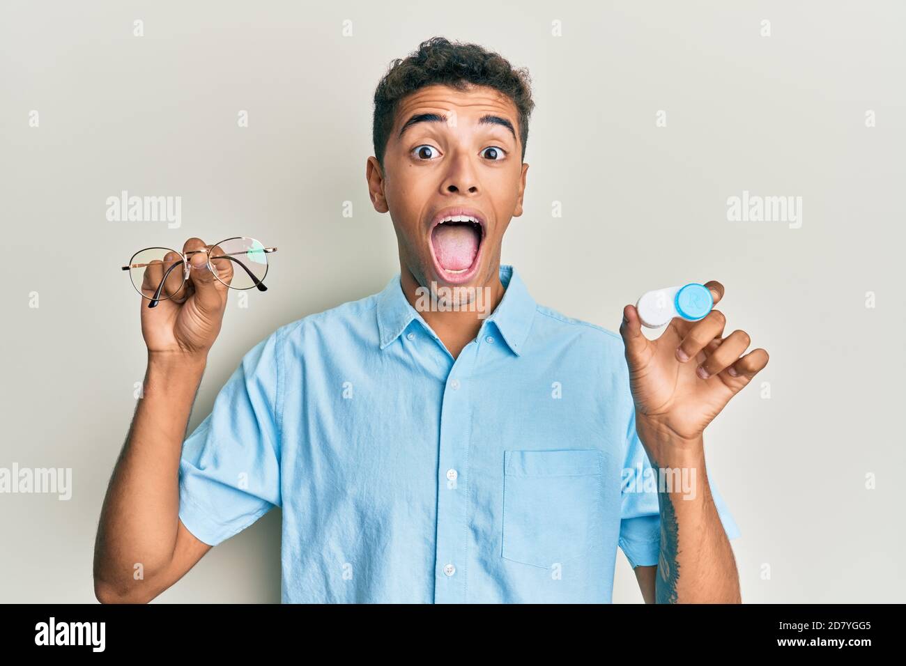 Young Handsome African American Man Holding Glasses And Contact Lenses