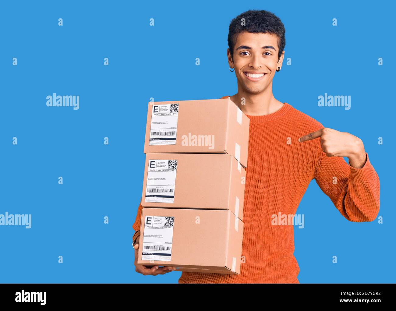 Young african amercian man holding delivery package pointing finger to ...